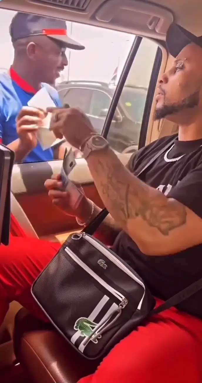 Davido's cousin, B-red spotted handing out money on the street (Video)
