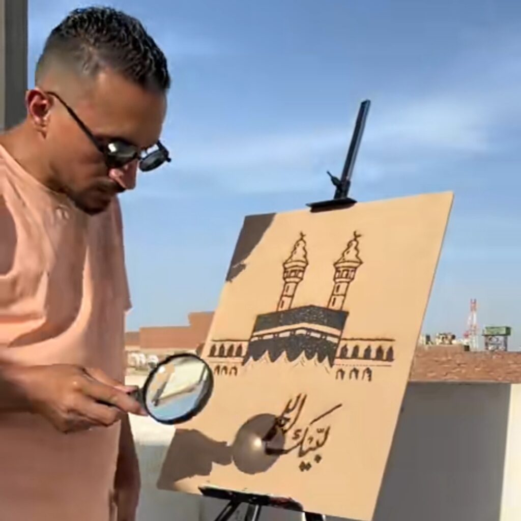 Artist creates Mecca image using sun's heat and magnifying lens
